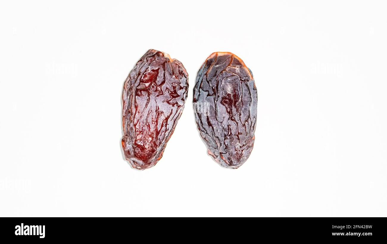 Two large dried dates on white background Stock Photo - Alamy