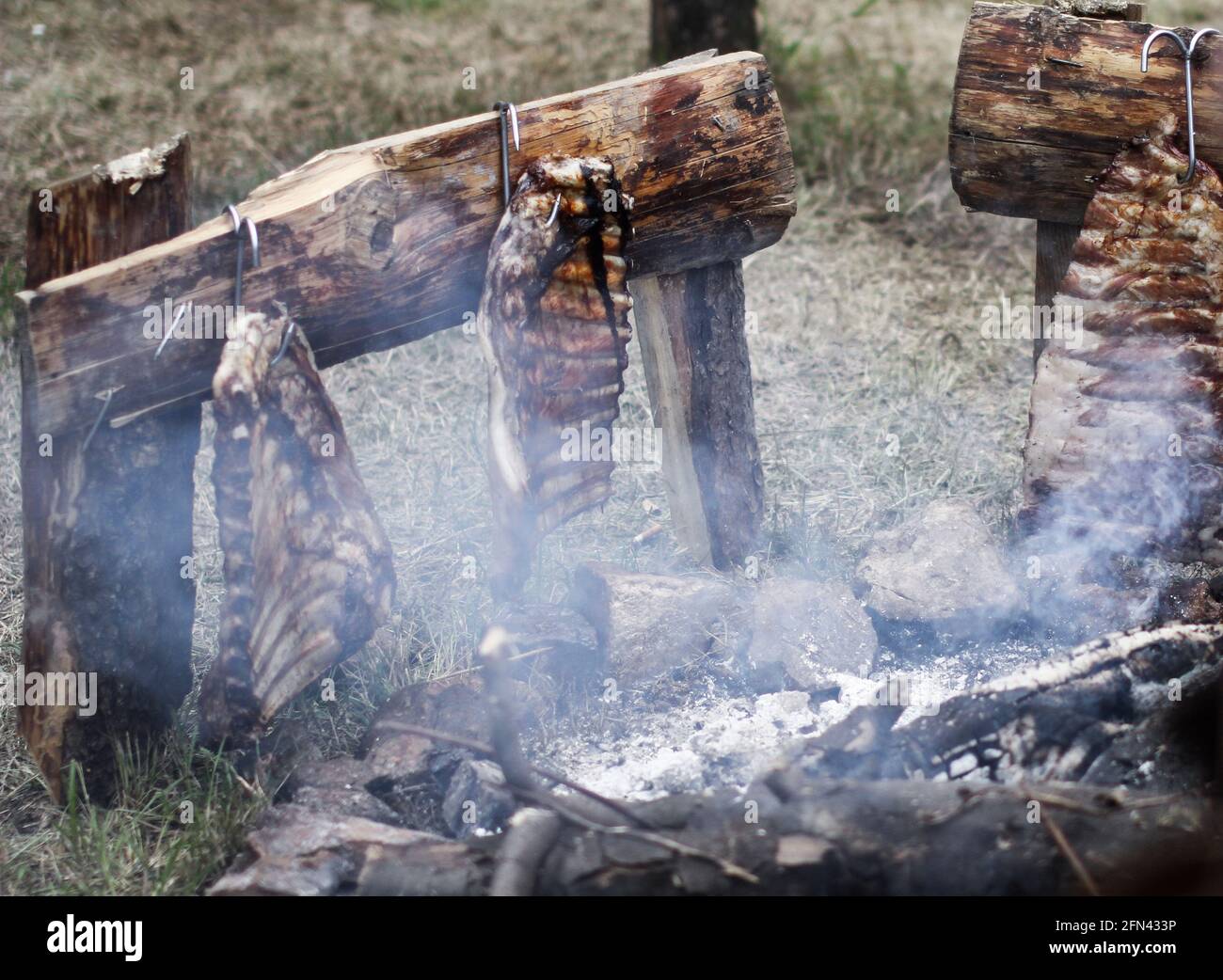 Smoked pork ribs on a campfire. Meat is cooking in the ancient medieval ...