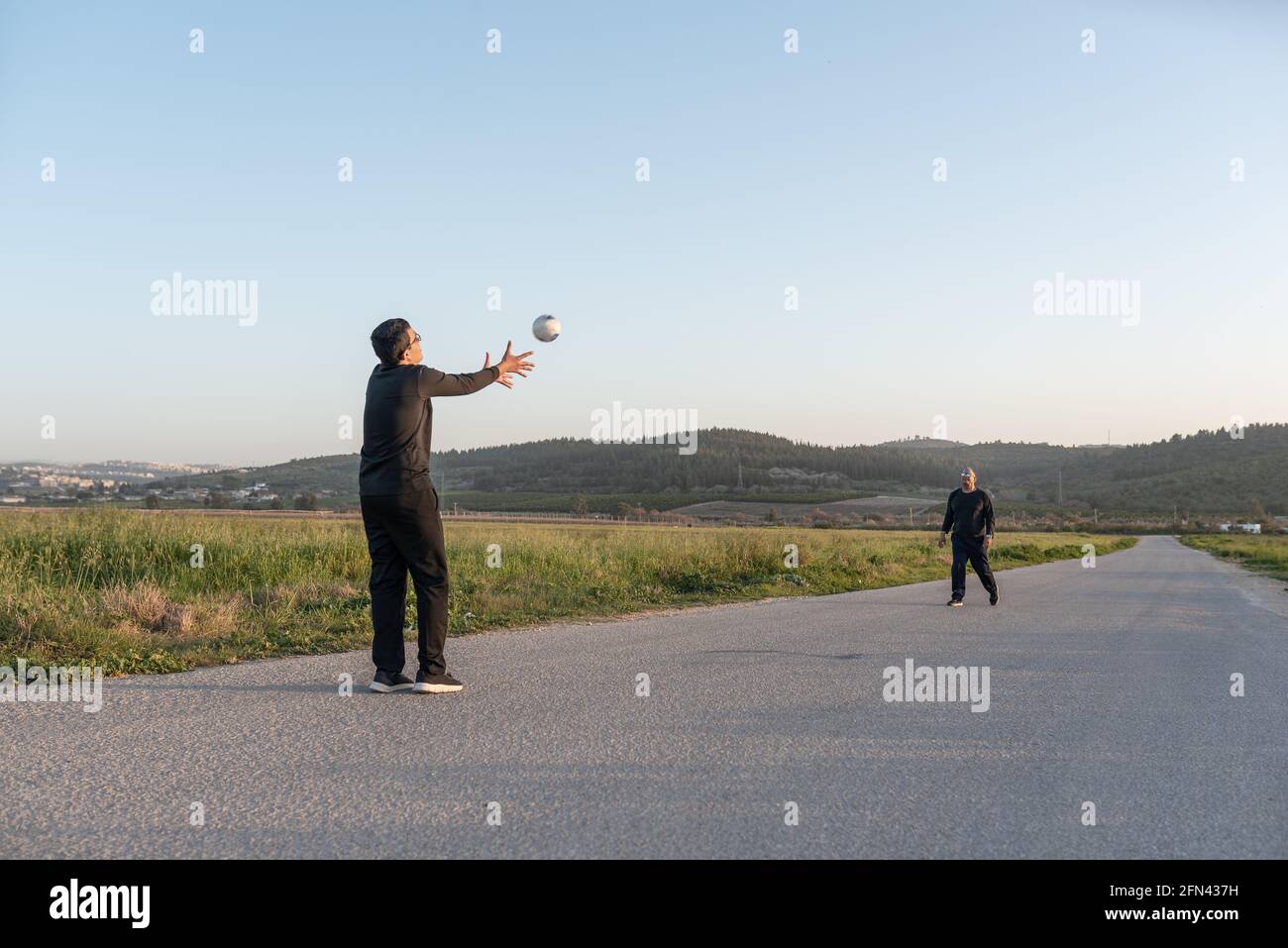 Handball players playing game outside.Senior father and teenager son ...