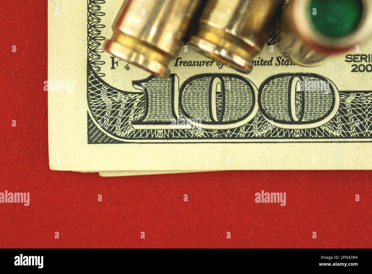 Criminal and bloody money concept with US hundred dollar bills and ammo ...