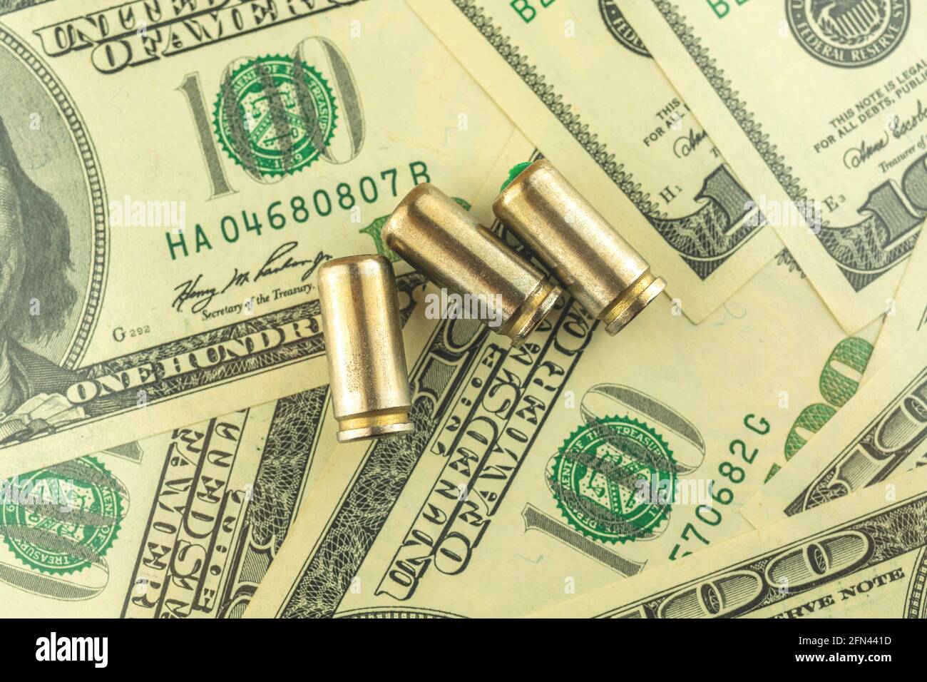 Bullet for a gun on table with US dollar banknotes, criminal and mafia ...