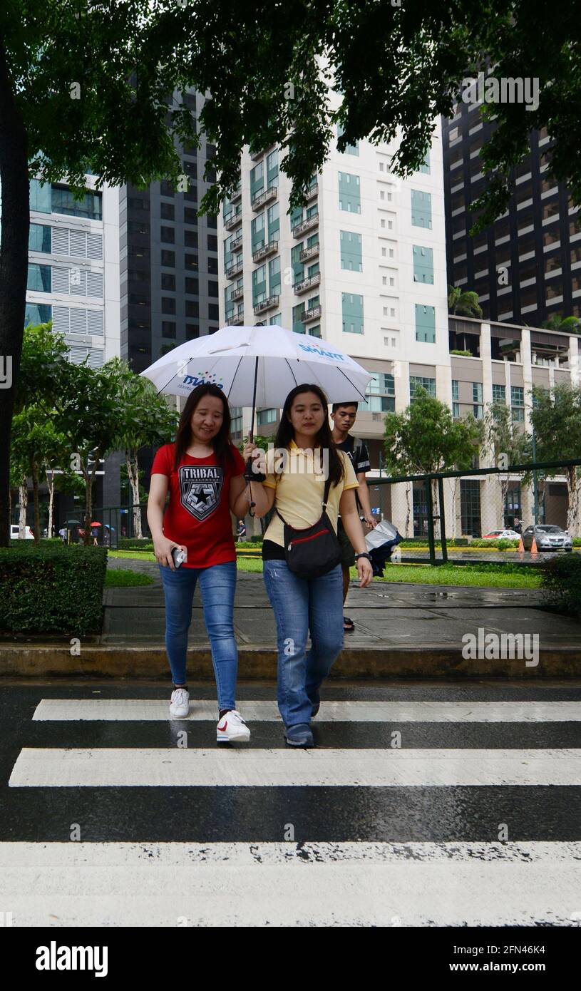 Crossing a wet road on a rainy day in Bonifacio Global City, Manila ...