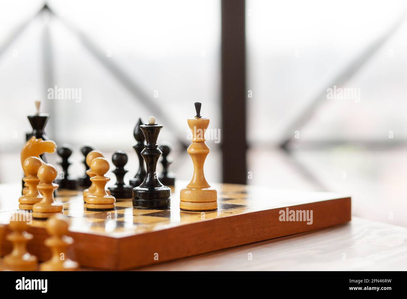 Wooden chess pieces on a board game, on vintage table, selective focus ...