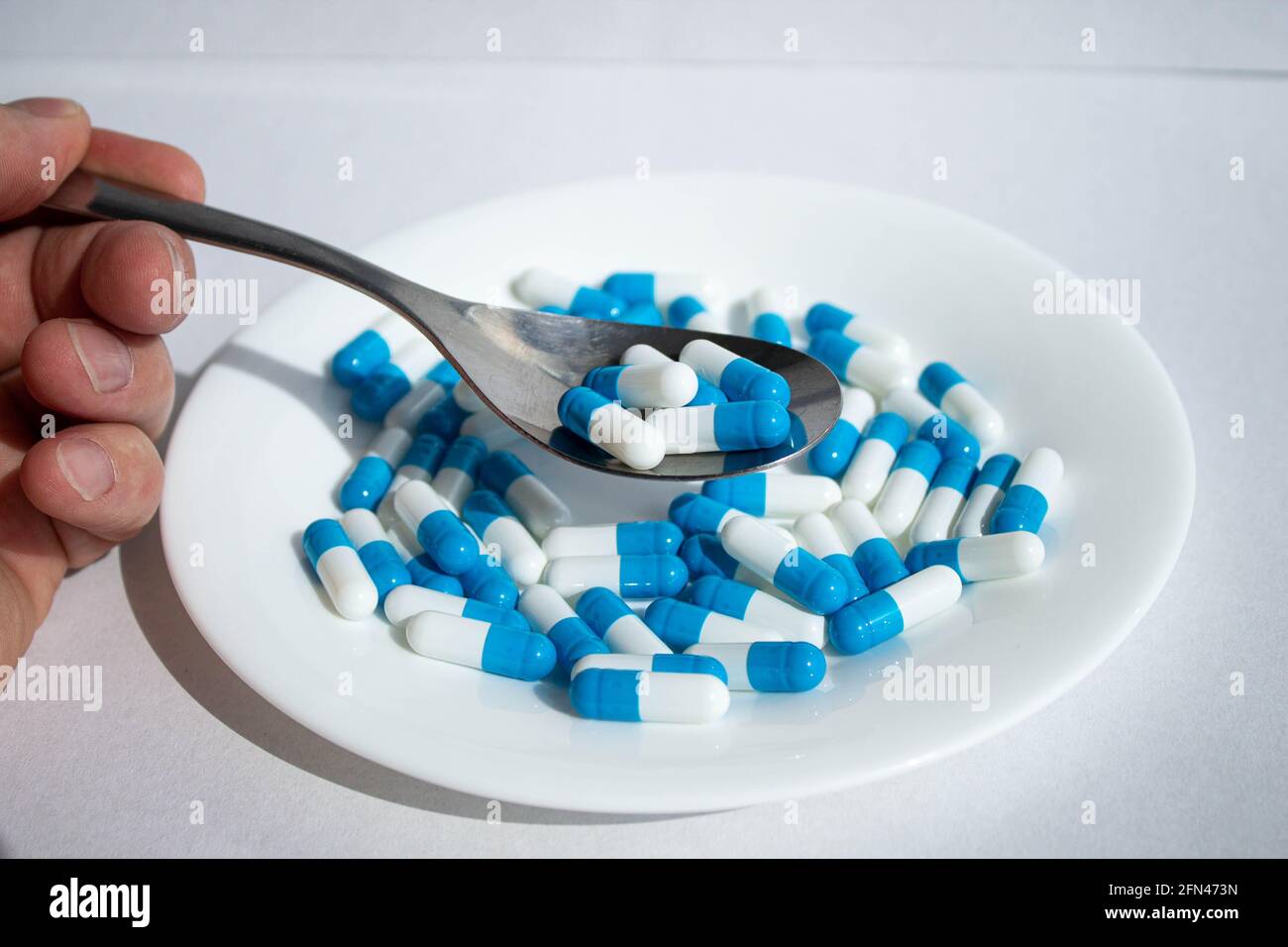 Tablets on a plate. Medicine for the patient on a spoon. Tablet on a ...