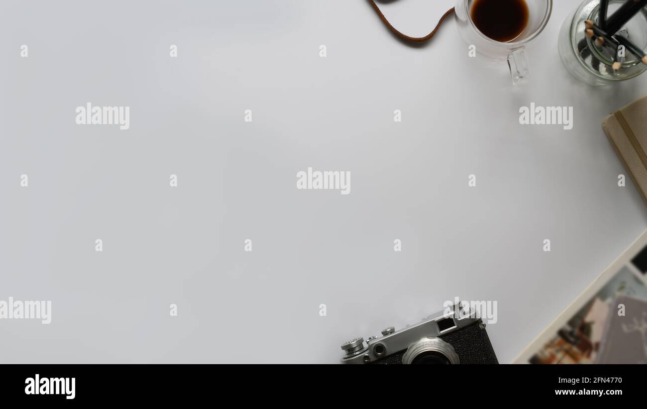 Top view of modern worktable with copy space, camera, office supplies ...
