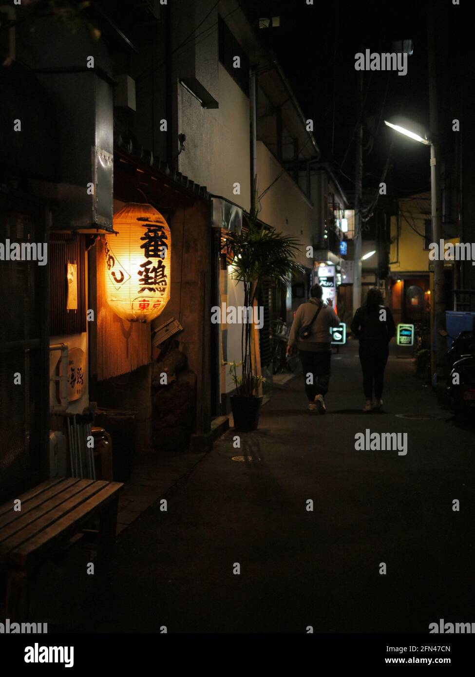 Japanese lantern in the city by night. A red lantern hanging outside a ...