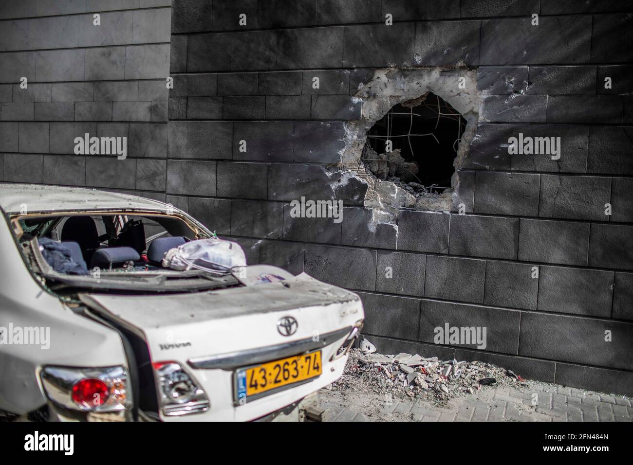 Ashkelon, Israel. 14th May, 2021. A destroyed car and a hole on a wall ...