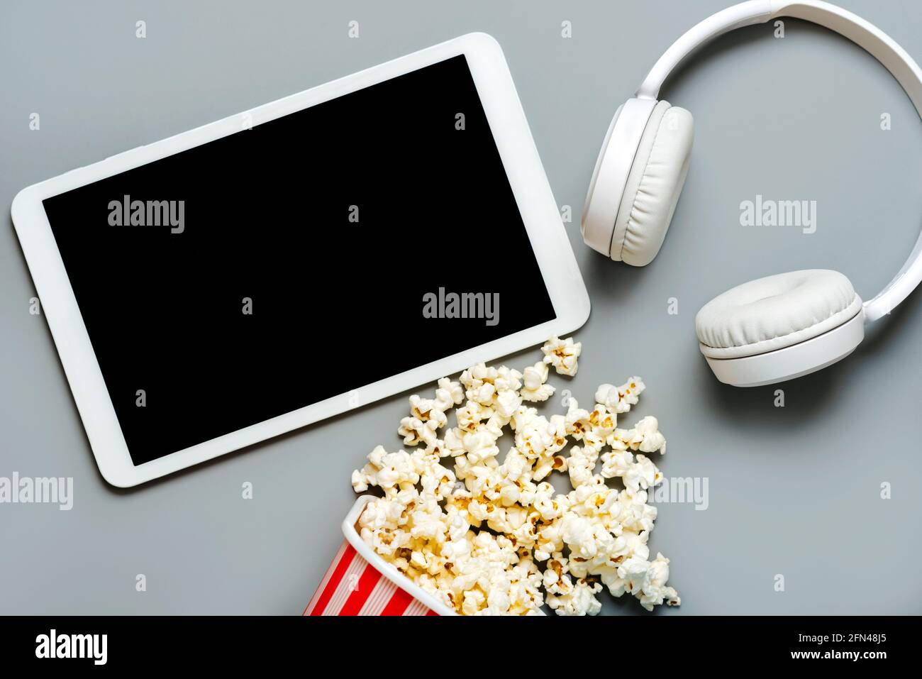 White digital tablet with black screen and copy space with popcorn and ...