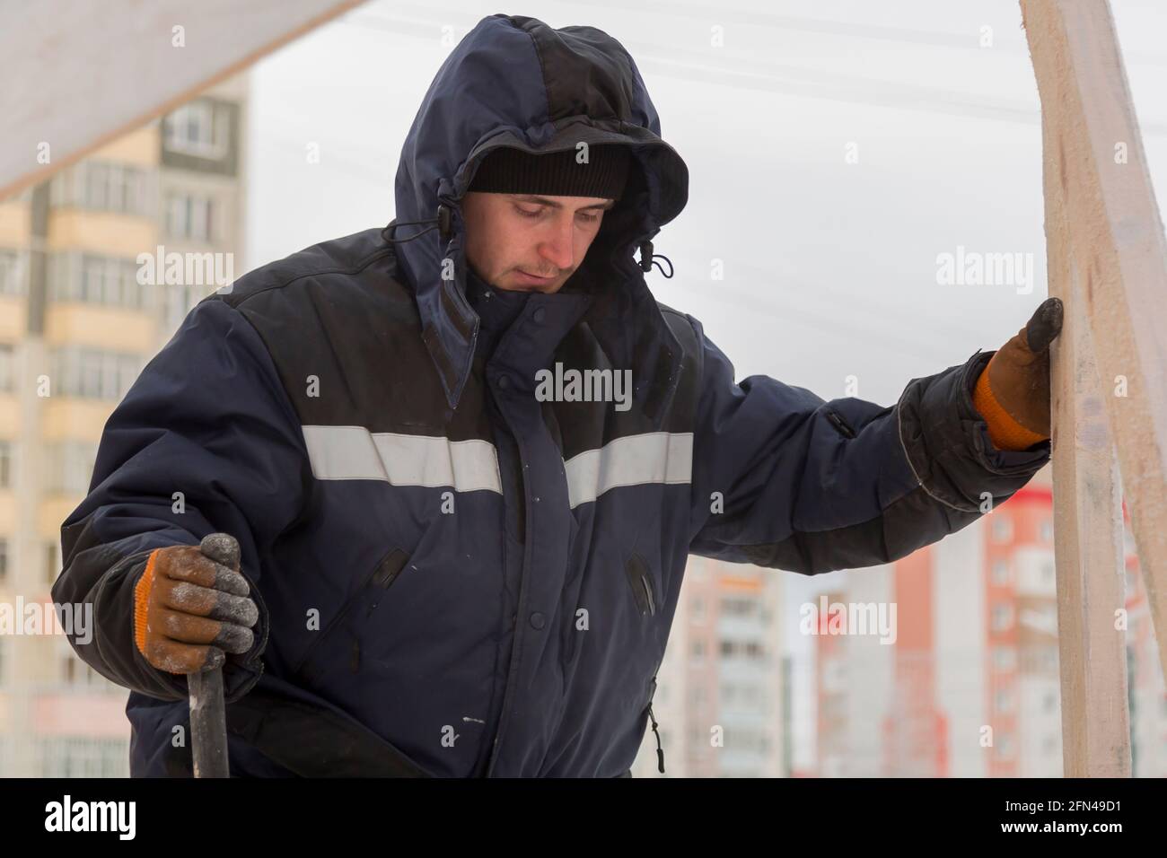 Worker on timber frame construction with crowbar in hand Stock Photo ...