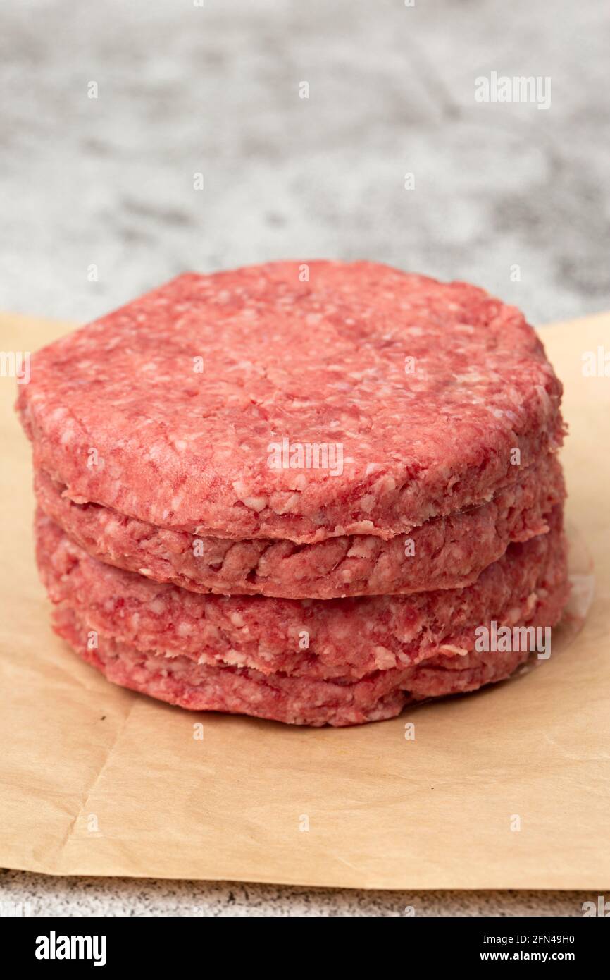 Raw beef burgers stacked on a brown paper bag. Environmentally friendly ...