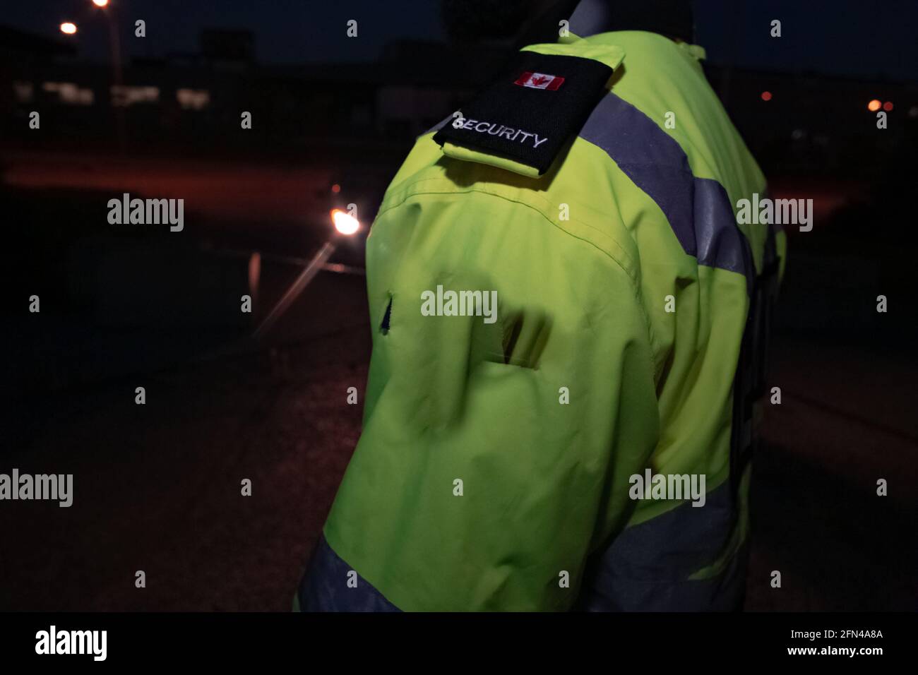 A rear view of a security guard looking down the street and sunset ...