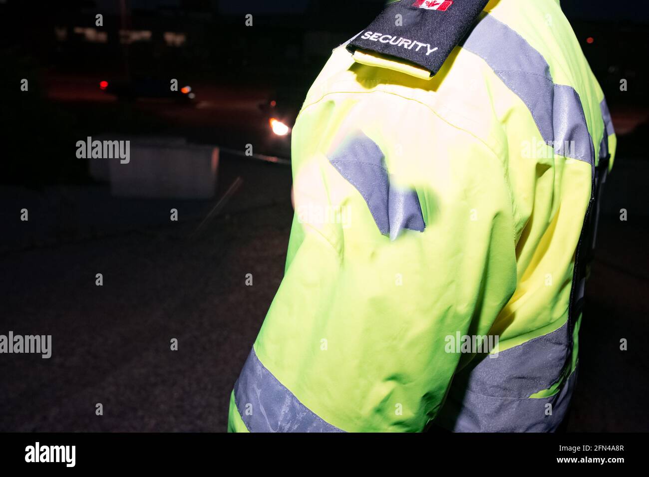A rear view of a security guard looking down the street and sunset ...