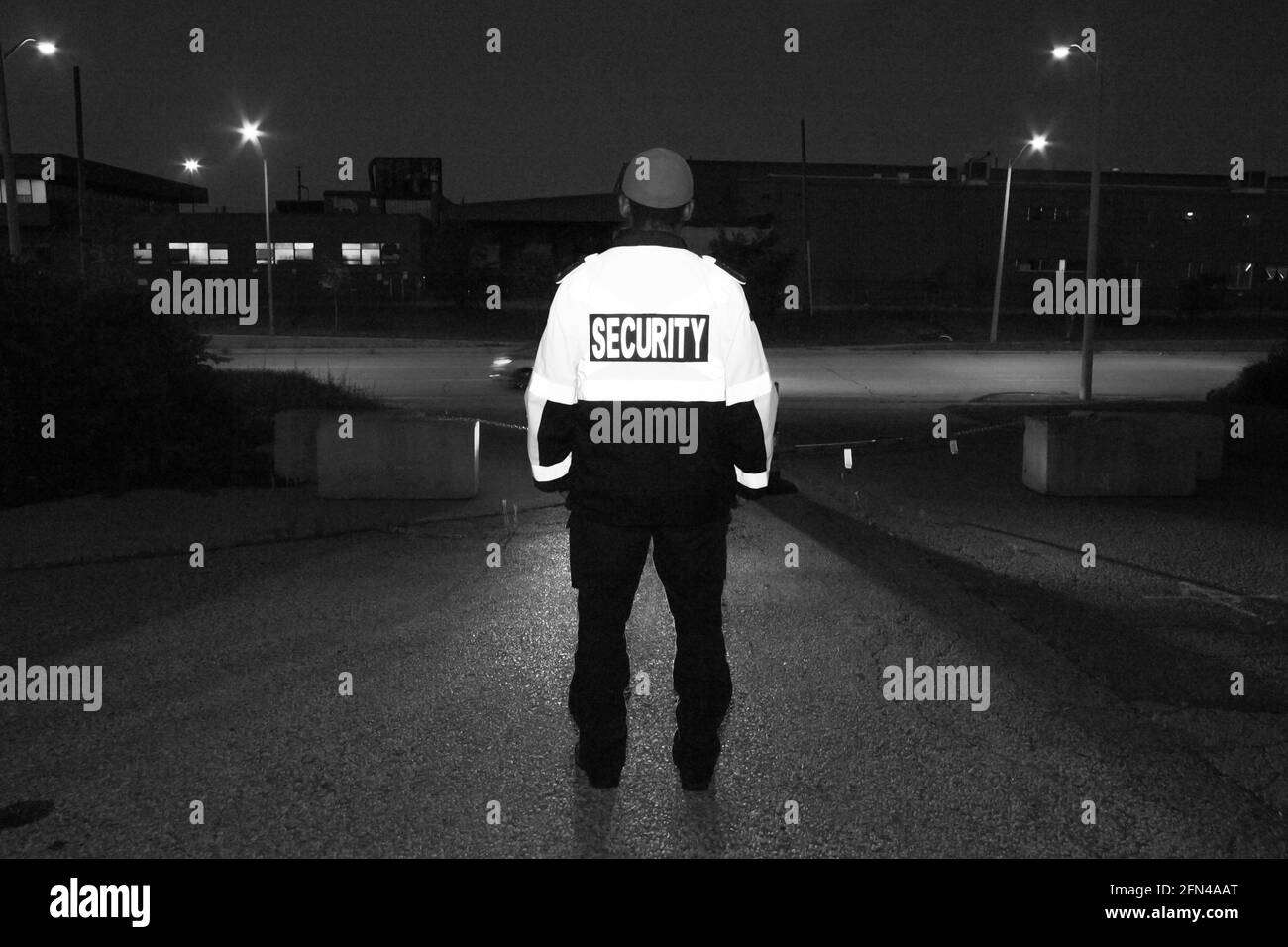 A rear view of a security guard looking down the street and sunset ...