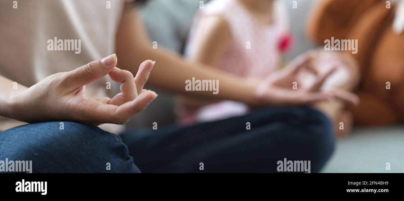 Side view of female rest on sofa meditating with mudra hands on her lap ...