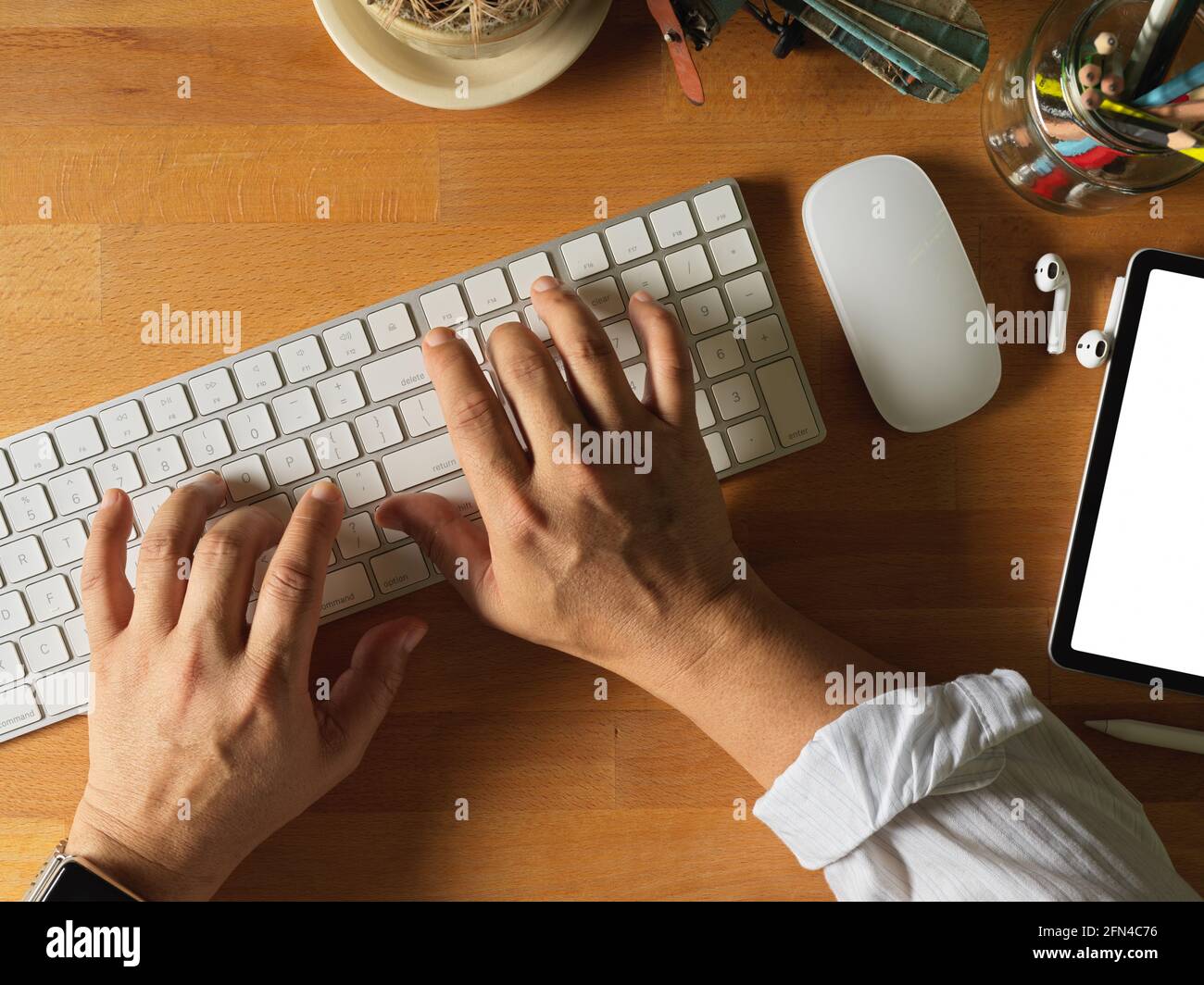 Top view of male hands typing on computer keyboard with supplies on ...