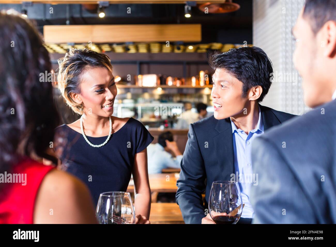 Asian friends sitting in restaurant Stock Photo - Alamy