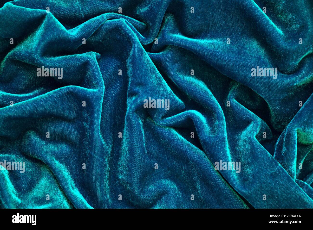 Close up of crumpled colourful crumpled turquoise blue velvet revealing ...