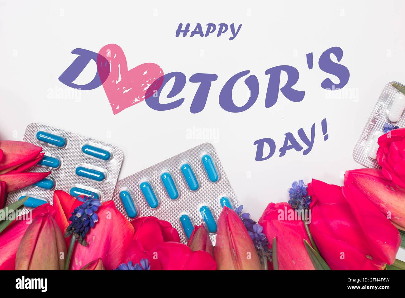 Flowers and pills with inscription Happy Doctor's Day on white ...