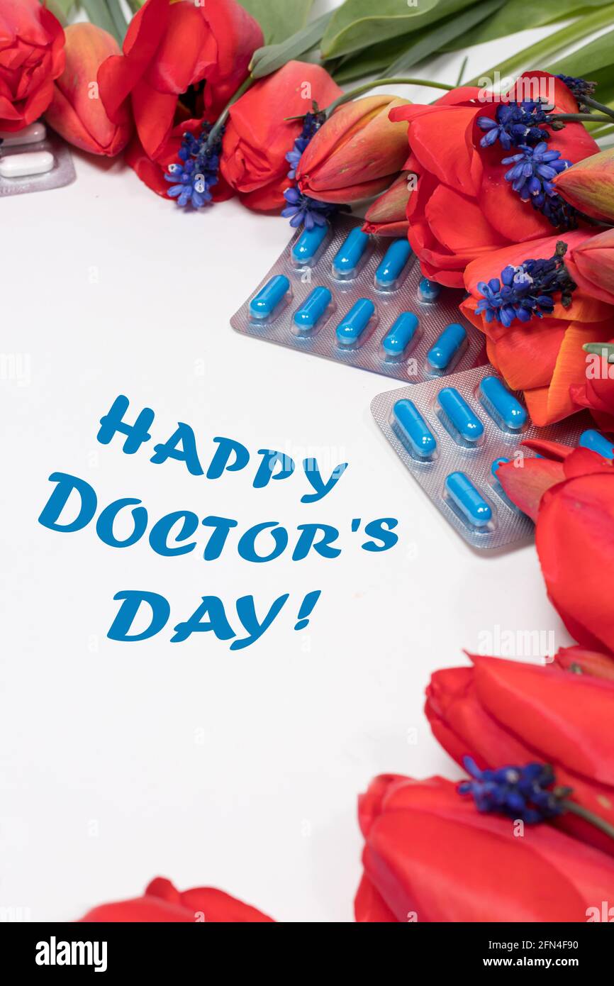 Flowers and pills with inscription Happy Doctor's Day on white ...