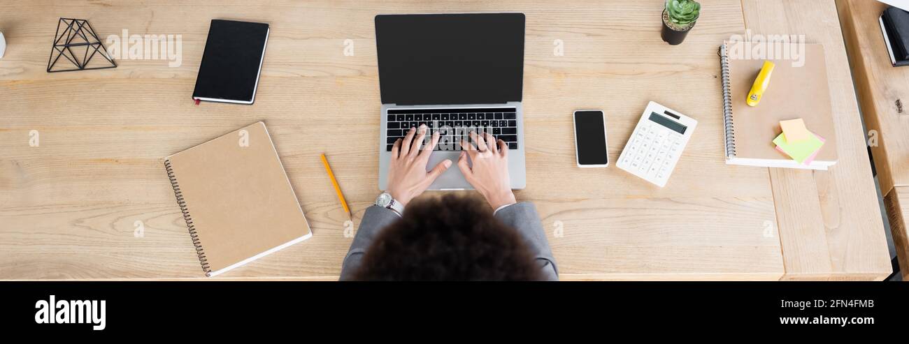 Overhead view of african american businesswoman using laptop with blank ...