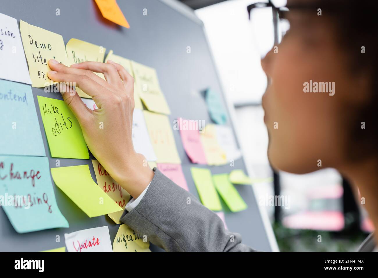 Sticky notes with lettering on board near blurred african american ...