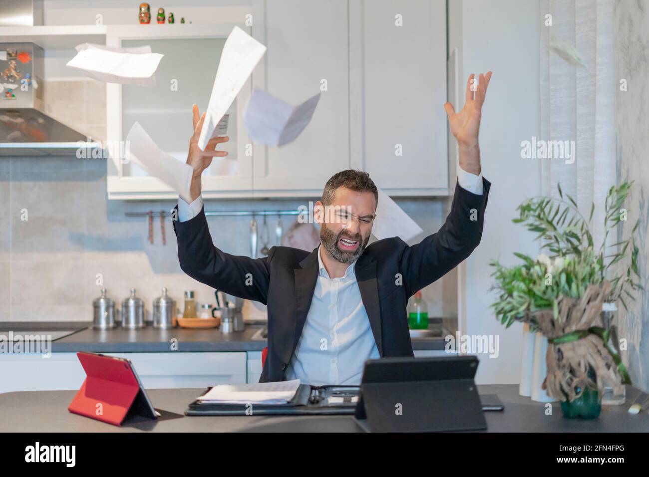 Angry businessman sitting in kitchen at home. Caucasian young man ...