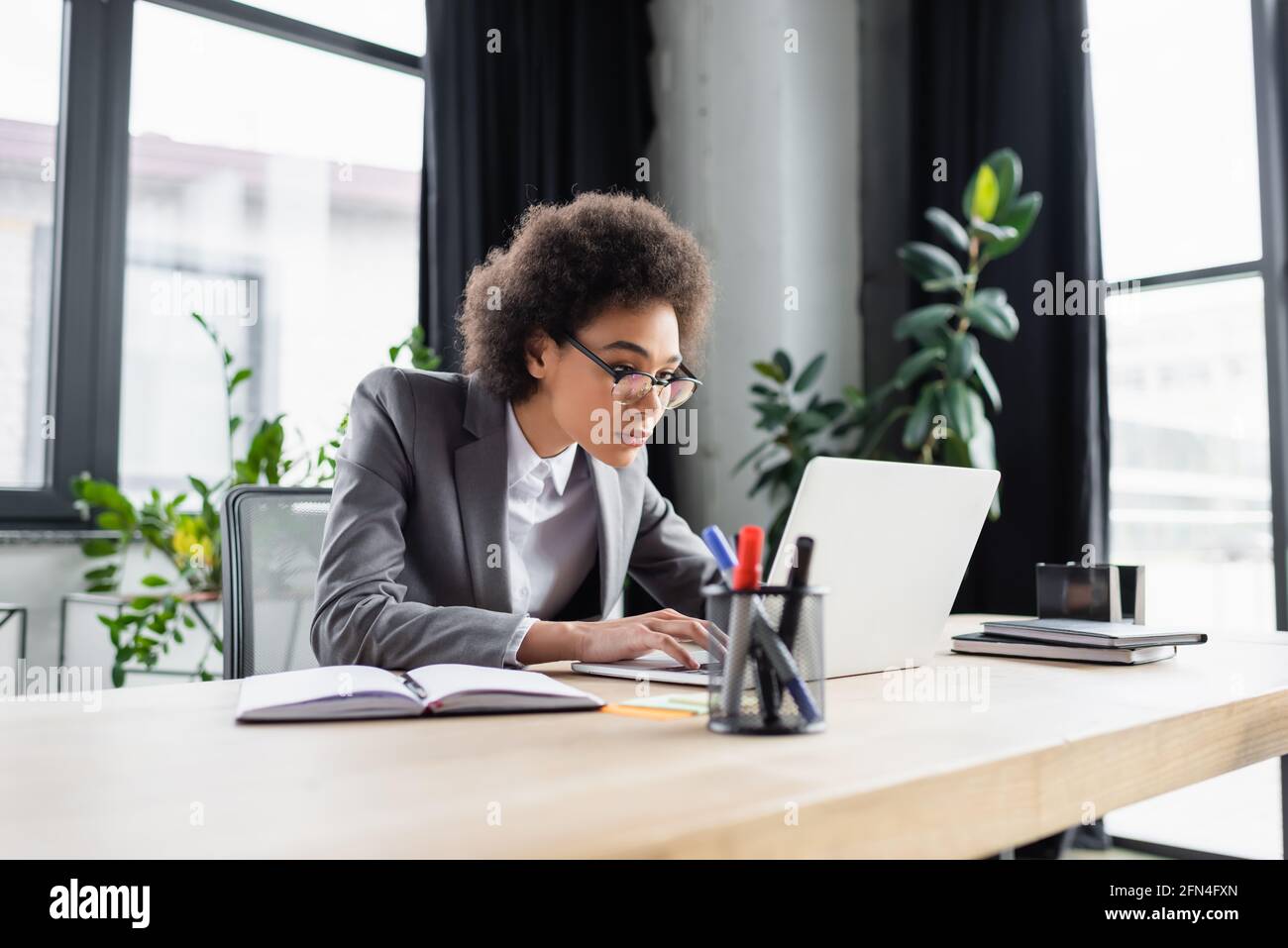 African american manager using laptop in office Stock Photo - Alamy