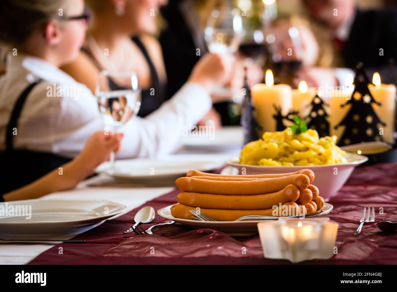 German parents and children toasting with wine and water at Christmas ...