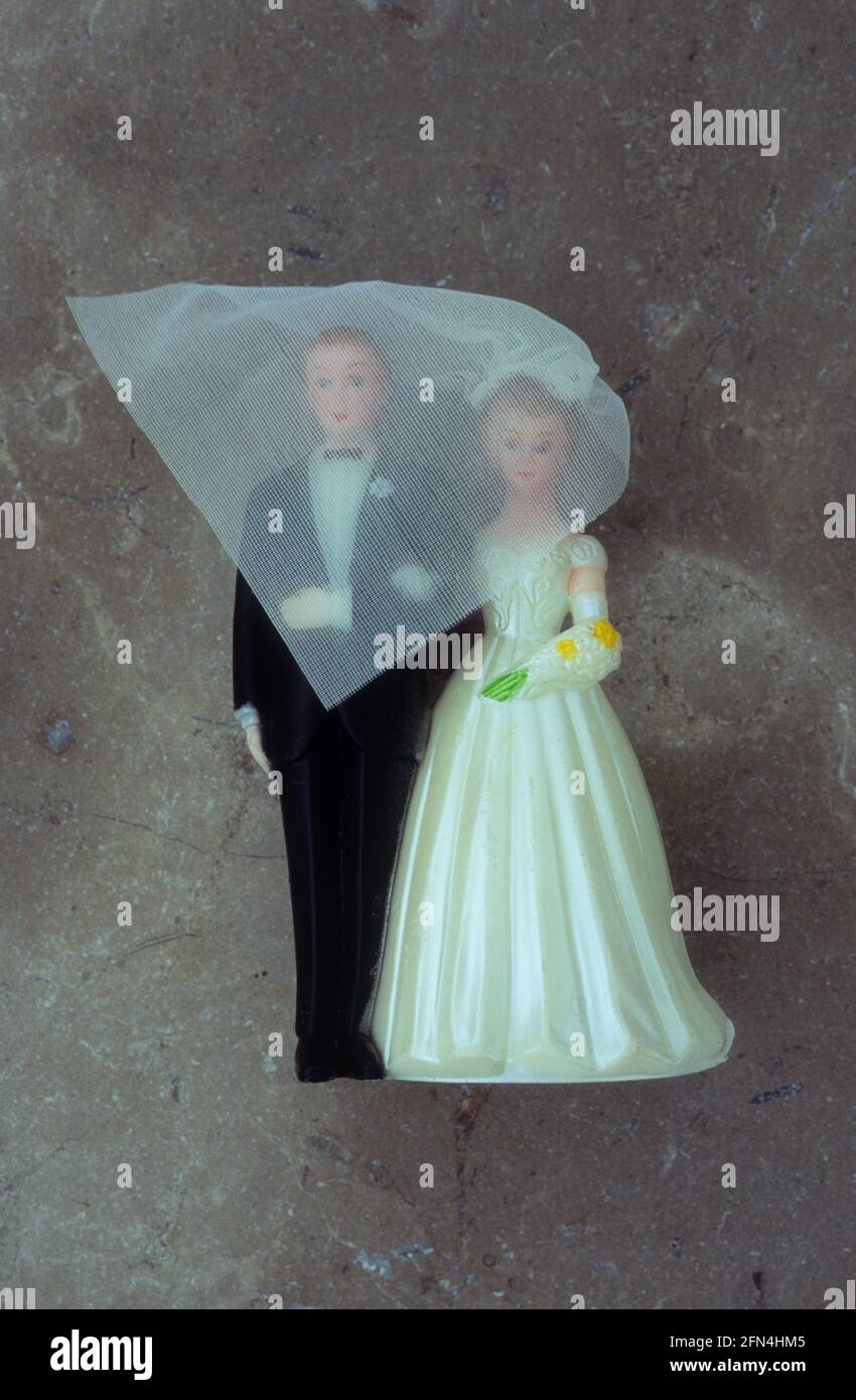Plastic model of wedding bride and groom with brides veil blown across ...