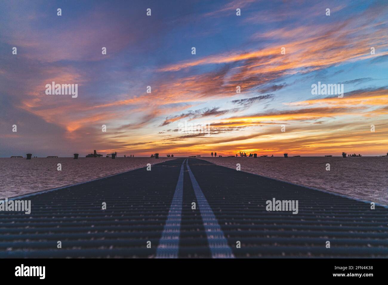 Beach boardwalk leading to shore against sunset sky Stock Photo - Alamy