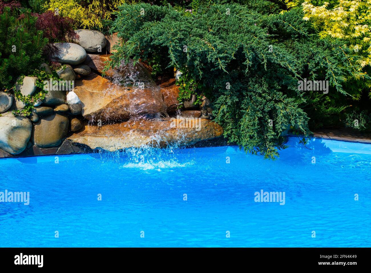 Swimming Pool water fall. Vacation concept Stock Photo - Alamy