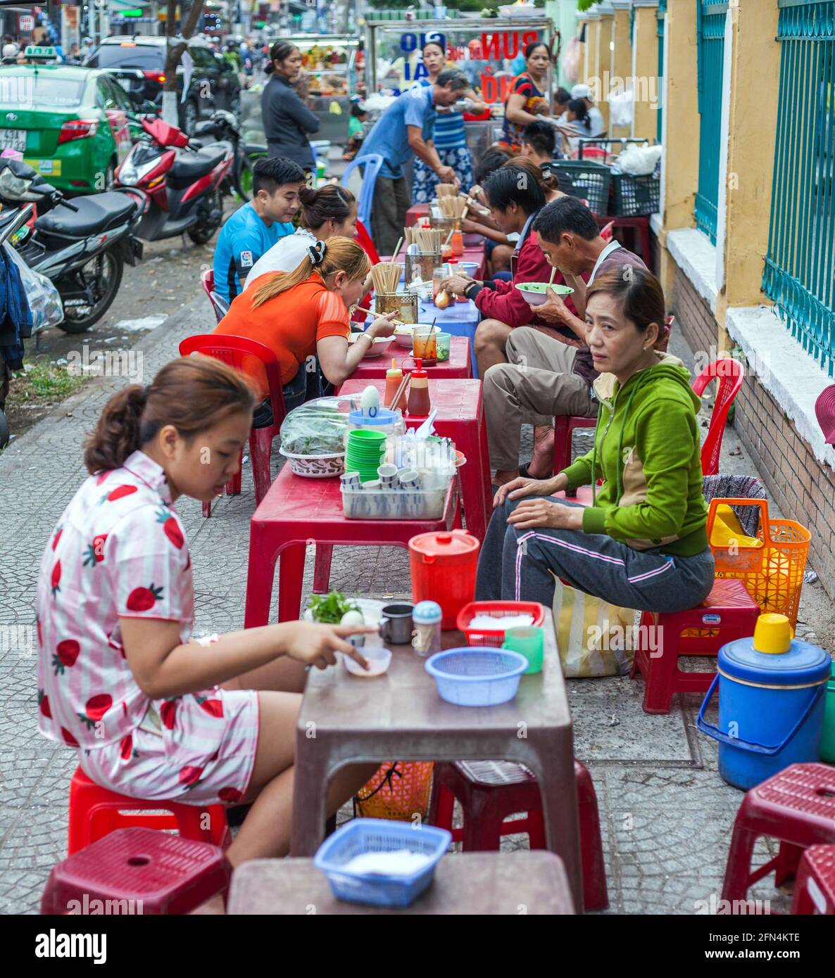 Vietnamese families eat street food at pavement cafe - only 1 person in ...