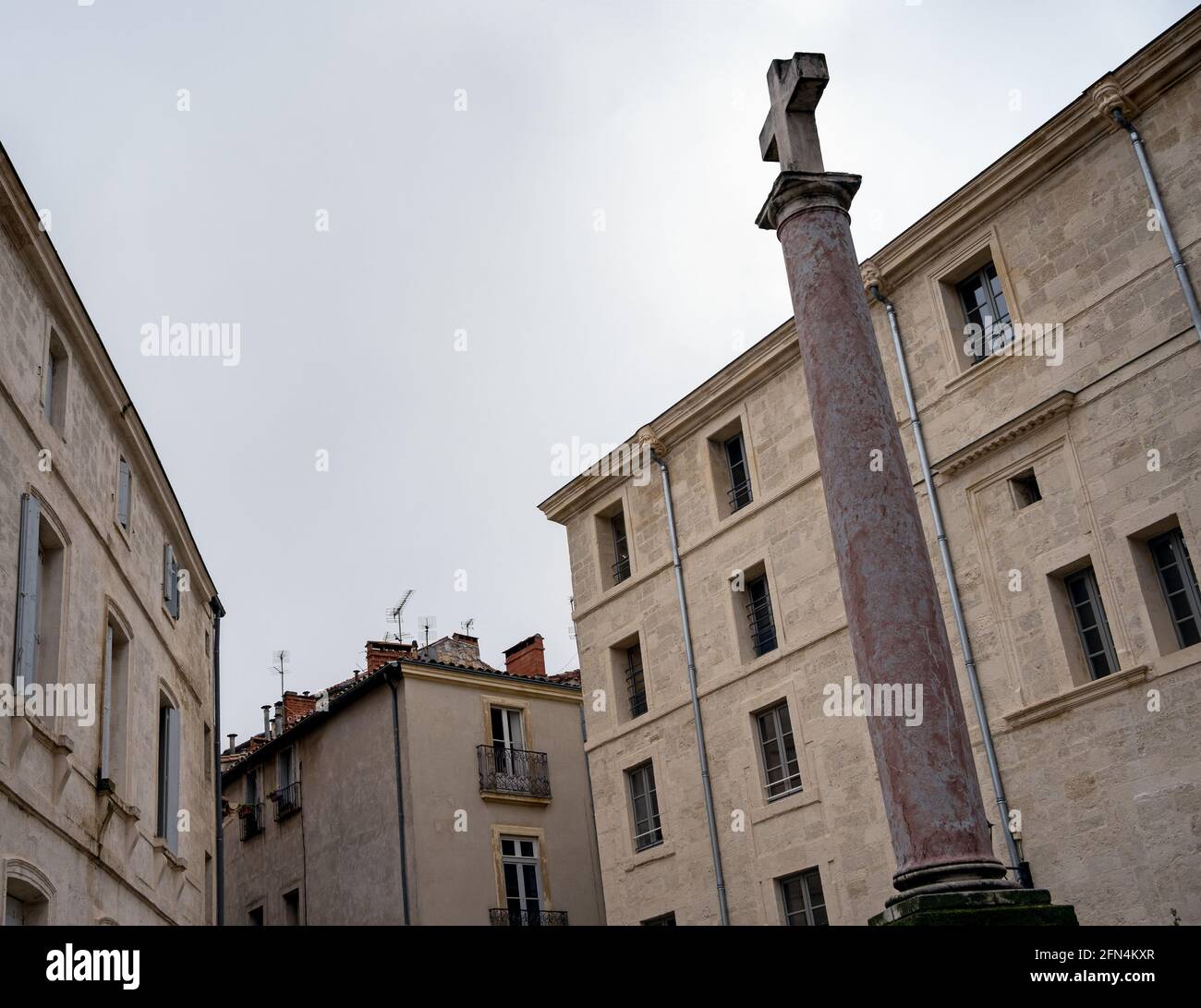 Traditional building structures in Montpellier with a high cross on a ...