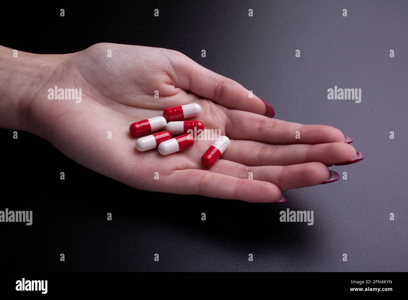 Woman with some drug capsules on palm of hand - black background Stock ...