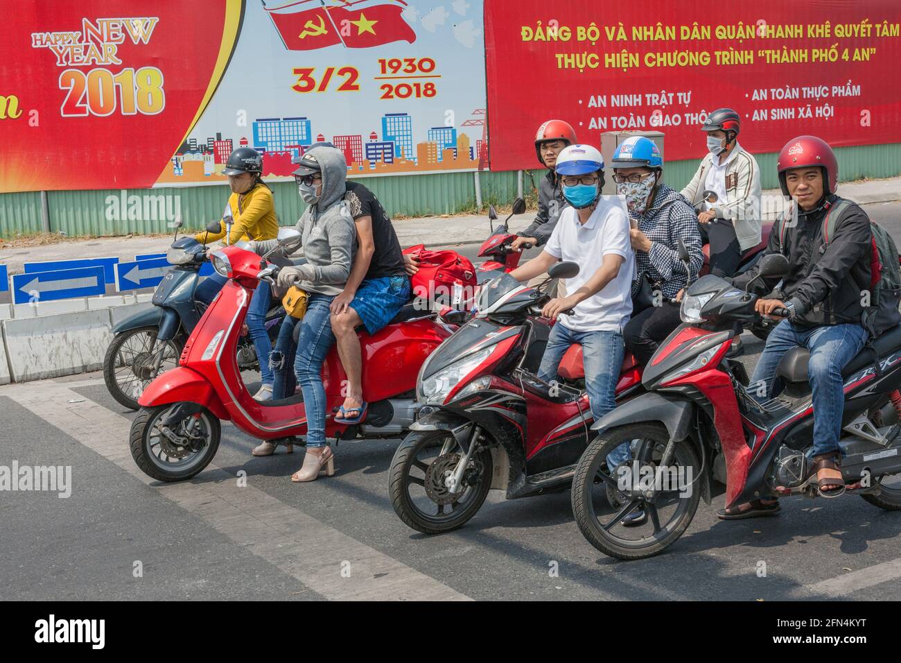 Vietnamese females driving scooters sit patiently at traffic junction ...