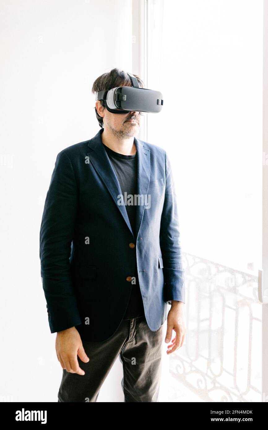 Adult male with face mask protection experiencing virtual reality ...