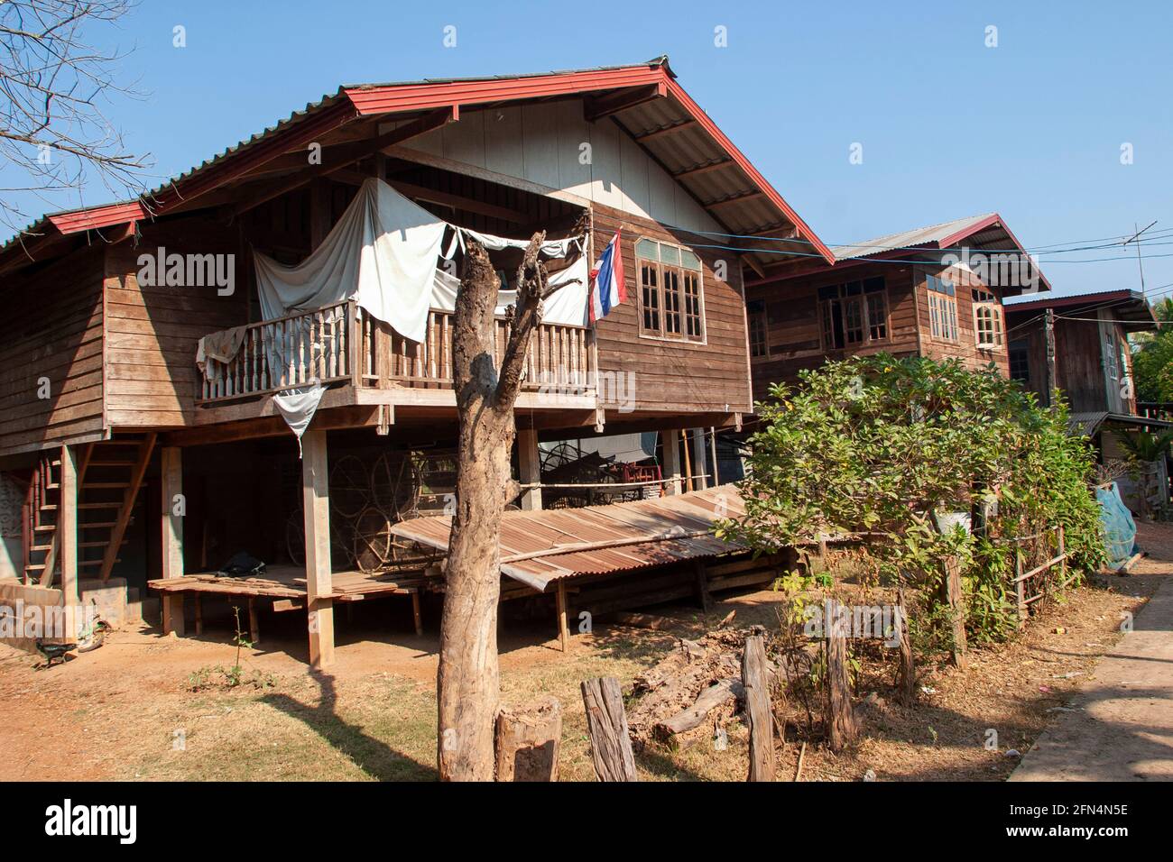 Traditional wooden Thai house elevated on stilts with corrugated iron ...