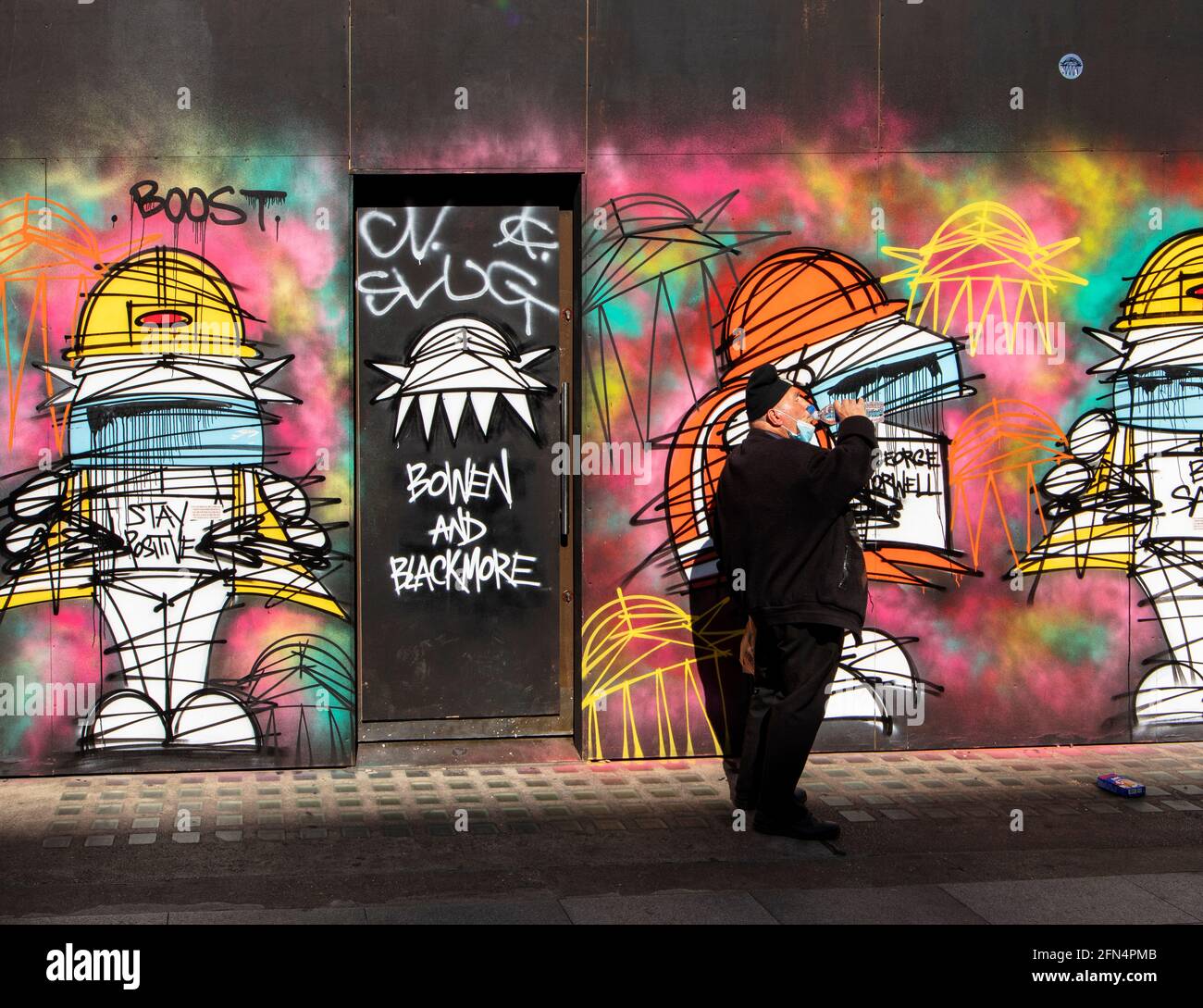 Man walking past Graffiti art by Nathan Bowen and Harry Blackmore in ...