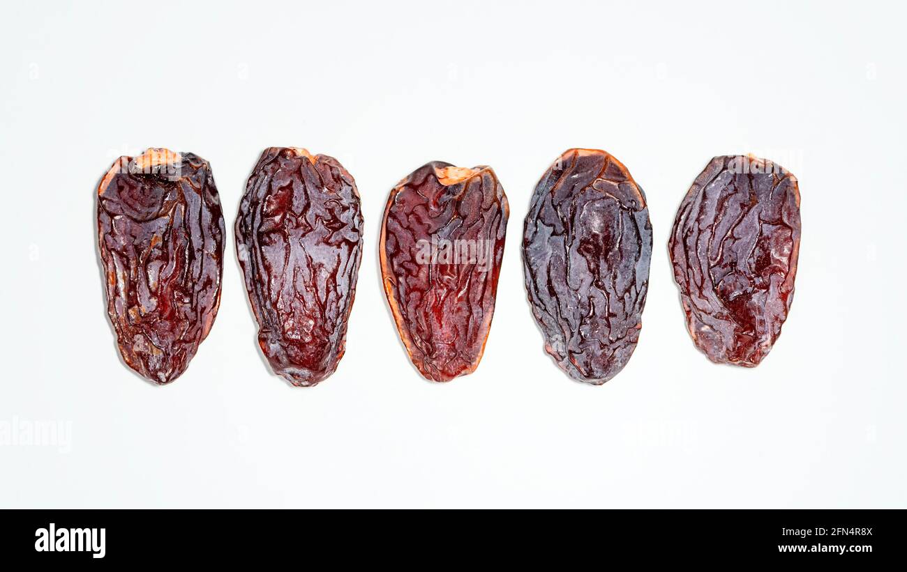 Five large dried dates on white background Stock Photo - Alamy