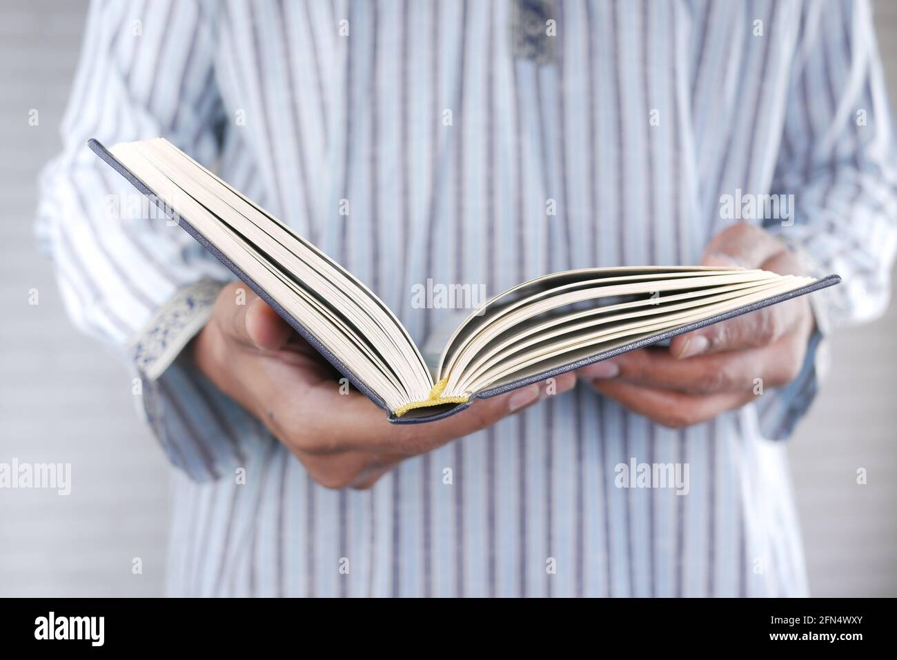 muslim man hand holding Holy book Quran with copy space Stock Photo - Alamy