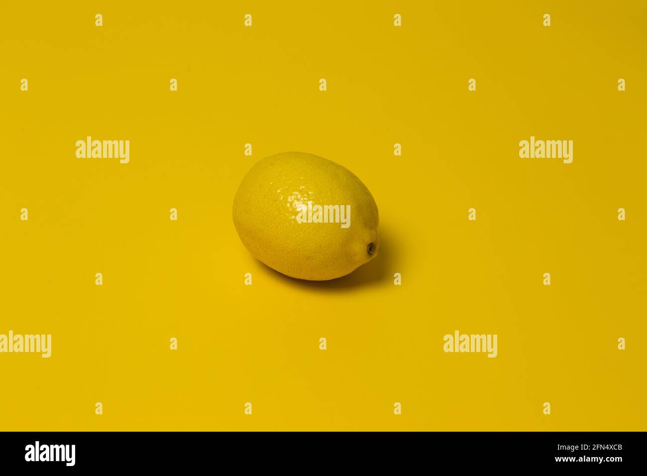 one yellow lemon in a yellow background Stock Photo - Alamy
