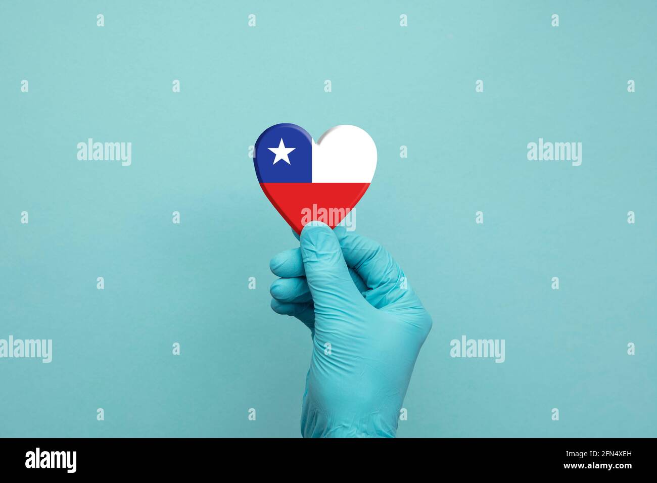 Hands wearing protective surgical gloves holding Chile flag heart Stock ...