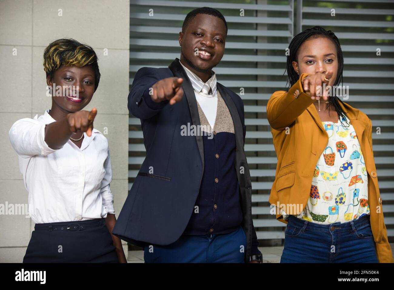 group of young business people standing outside looking at camera ...