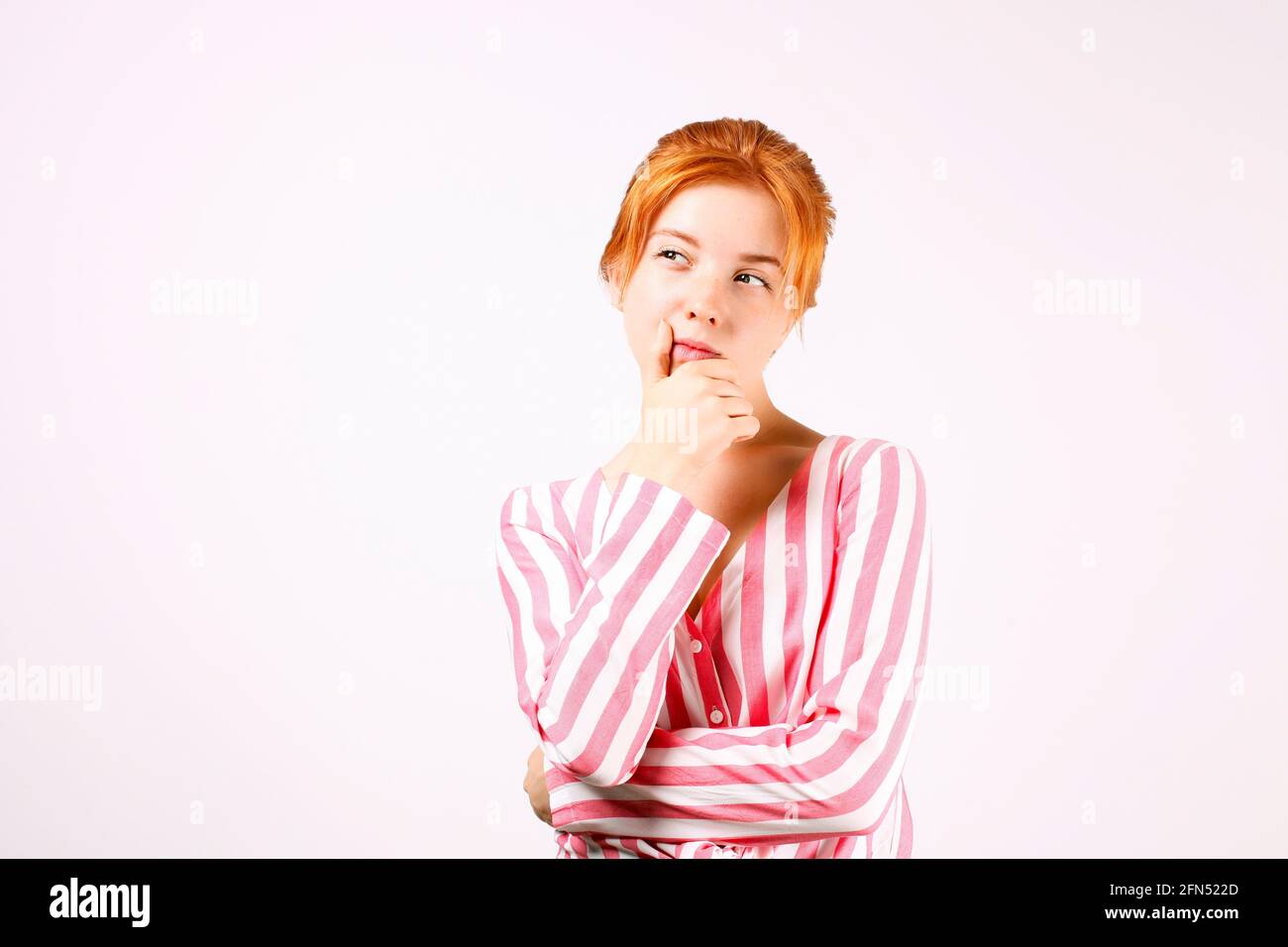 Young beautiful woman with long natural red hair, thinking facial ...
