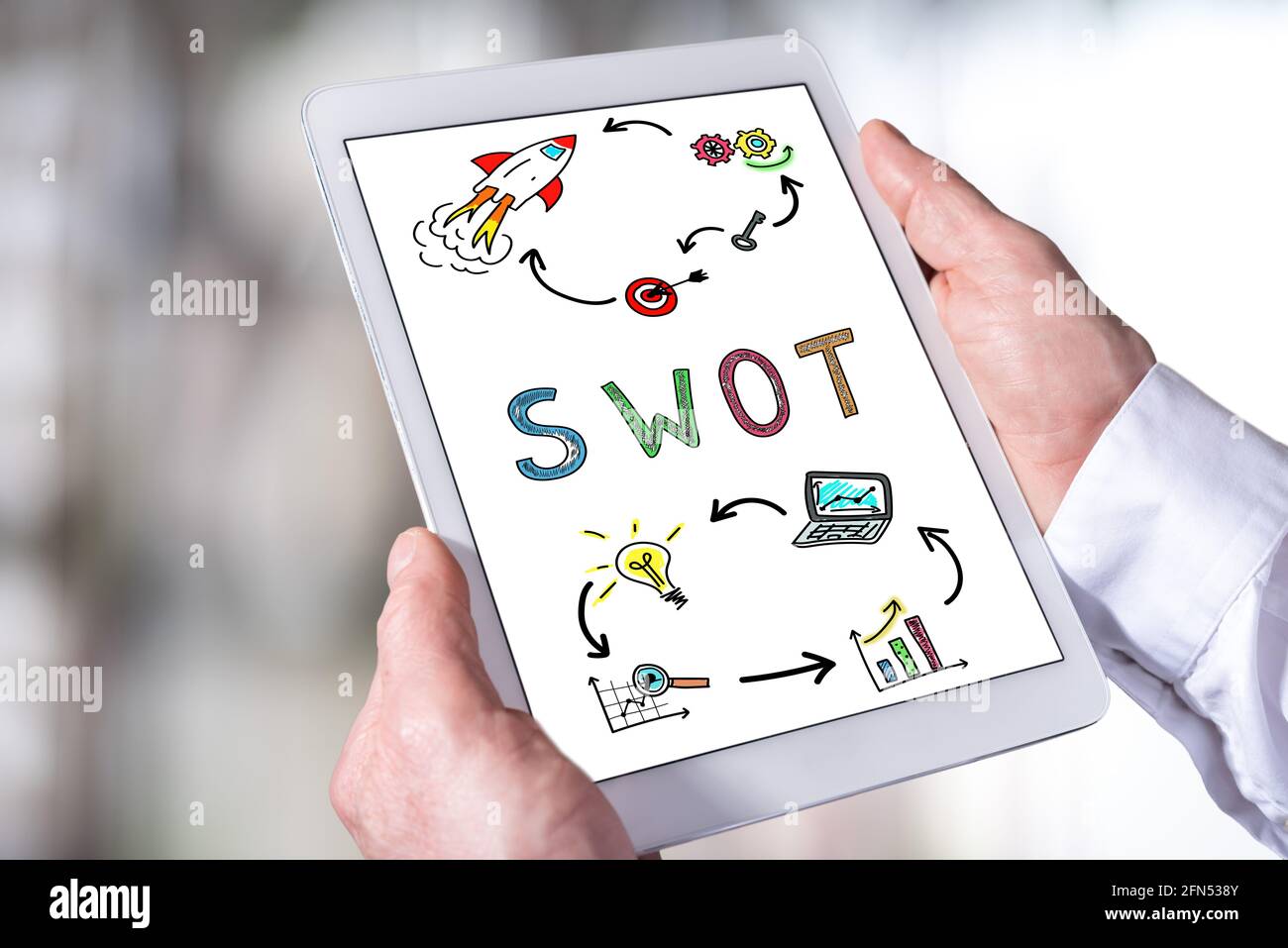 Man holding a tablet showing swot concept Stock Photo - Alamy