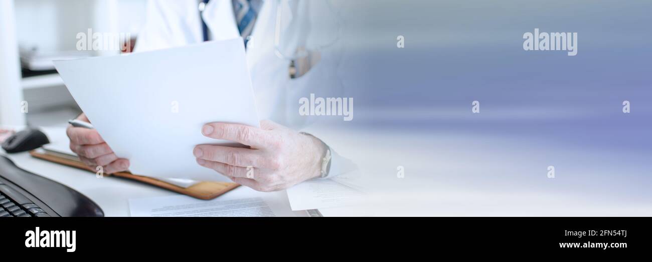 Doctor reading medical notes at his office; panoramic banner Stock ...