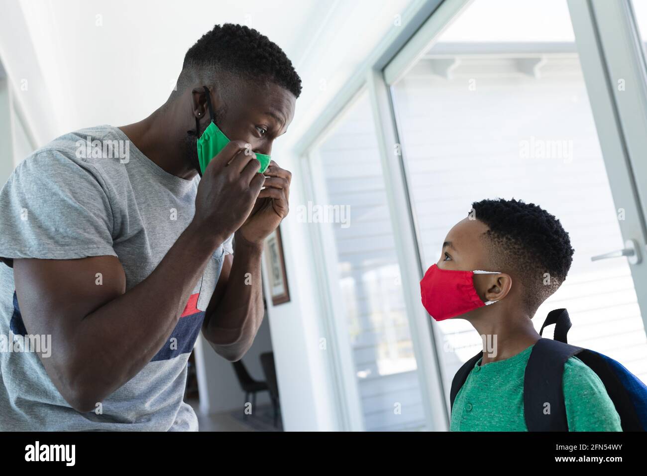 African american father and son putting on face masks Stock Photo - Alamy