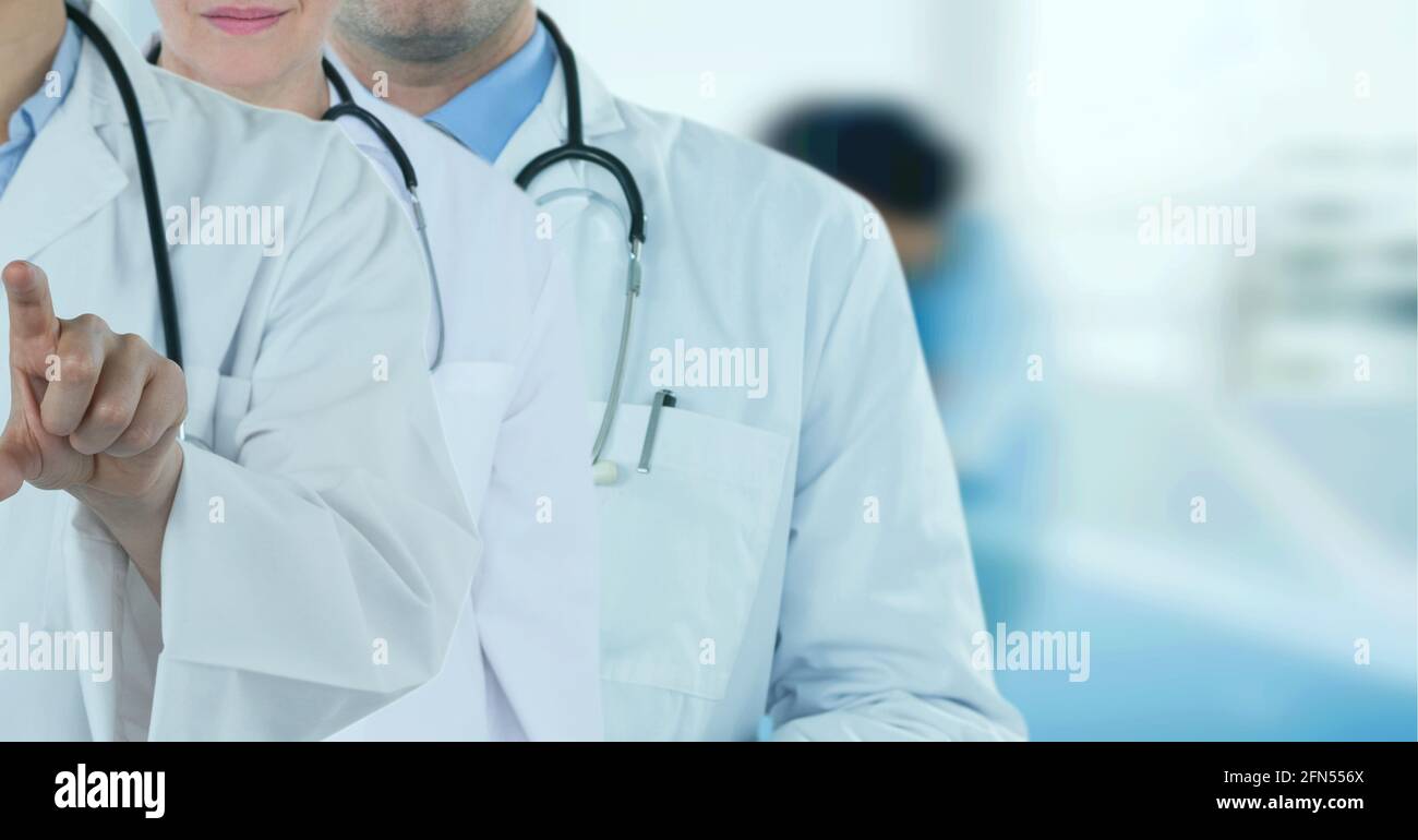 Mid section of team of doctors against hospital in background Stock ...