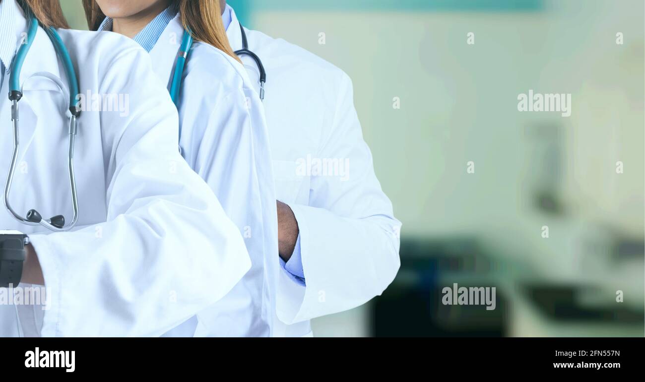 Mid section of team of doctors against hospital in background Stock ...