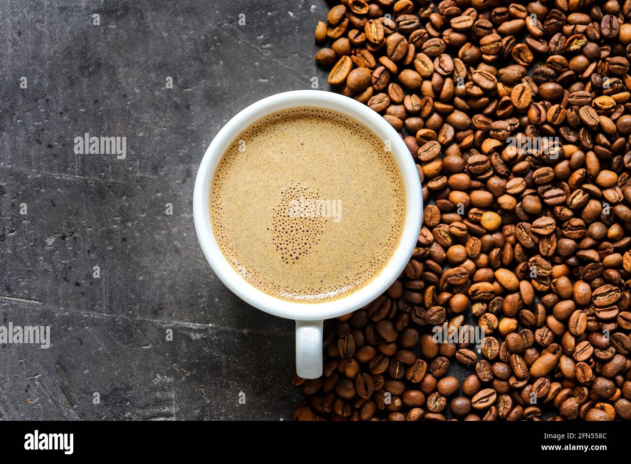 Horizontal banner with a cup of coffee and coffee beans on a dark ...